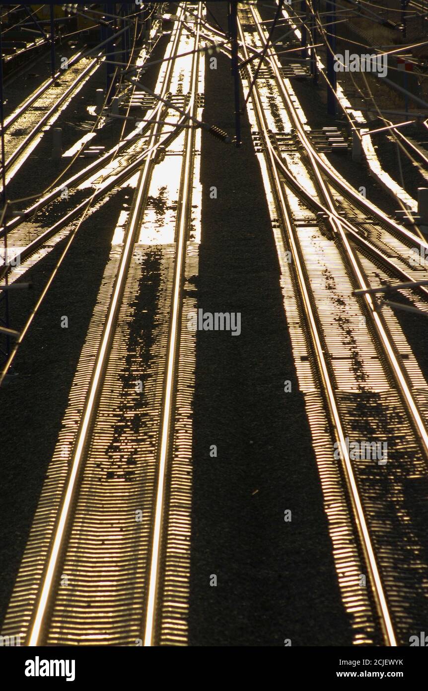 Illuminated train tracks at nightfall Stock Photo - Alamy