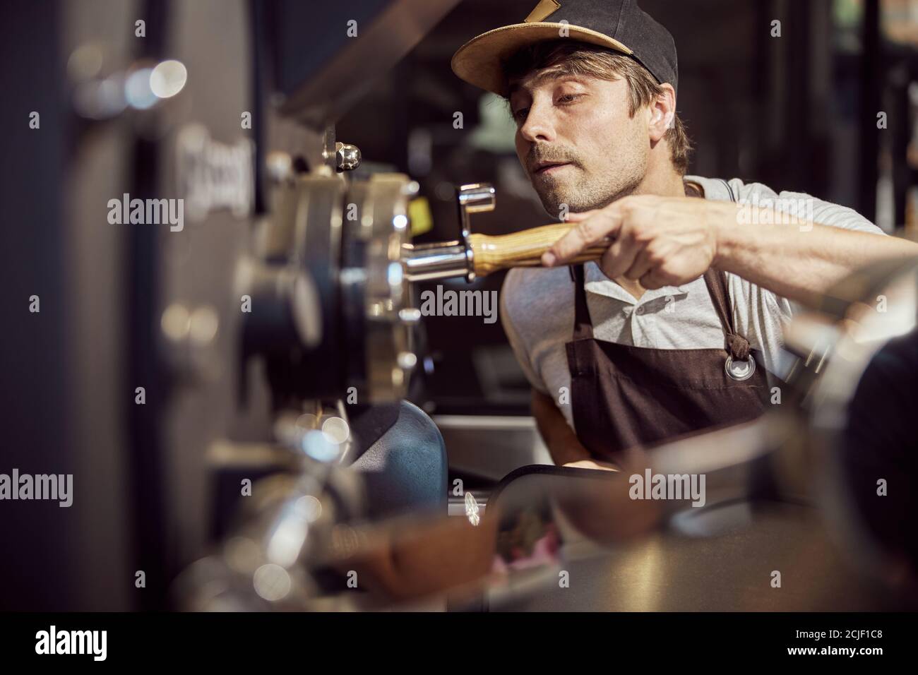 Professional roaster using coffee roasting machine at factory Stock ...