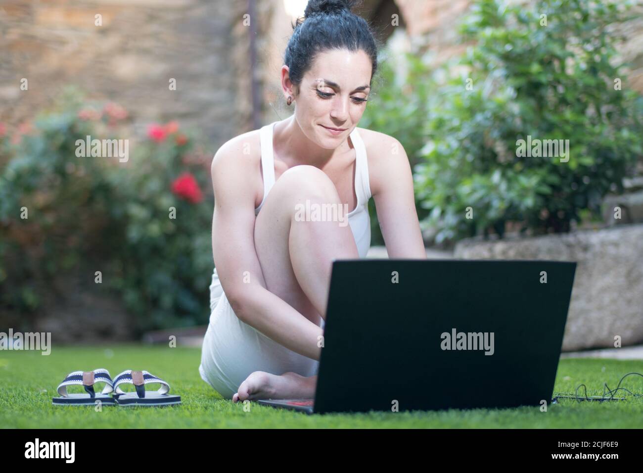 young girl sitting on the grass working on her computer Stock Photo - Alamy