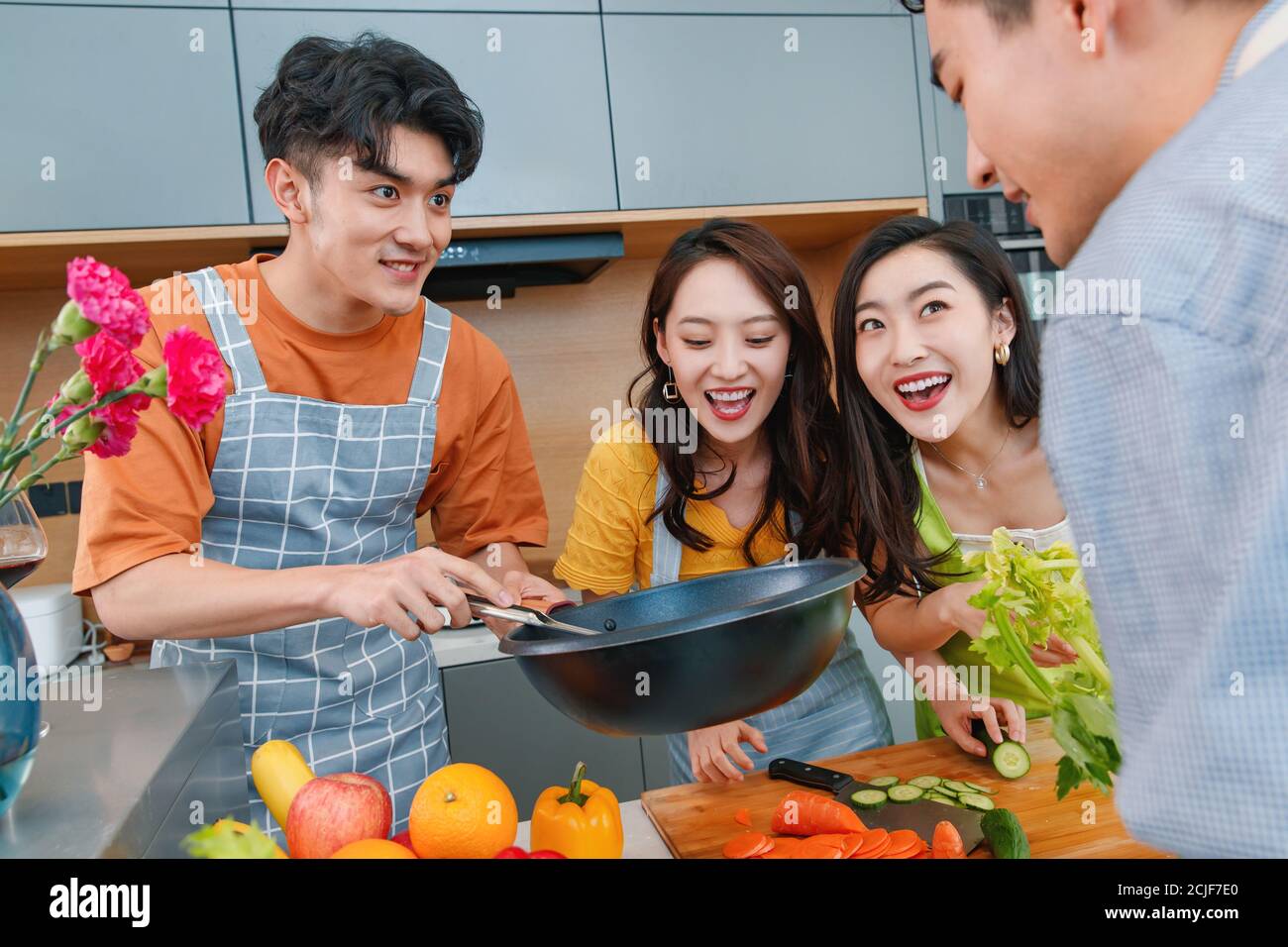 Happy young people cook in the kitchen Stock Photo - Alamy
