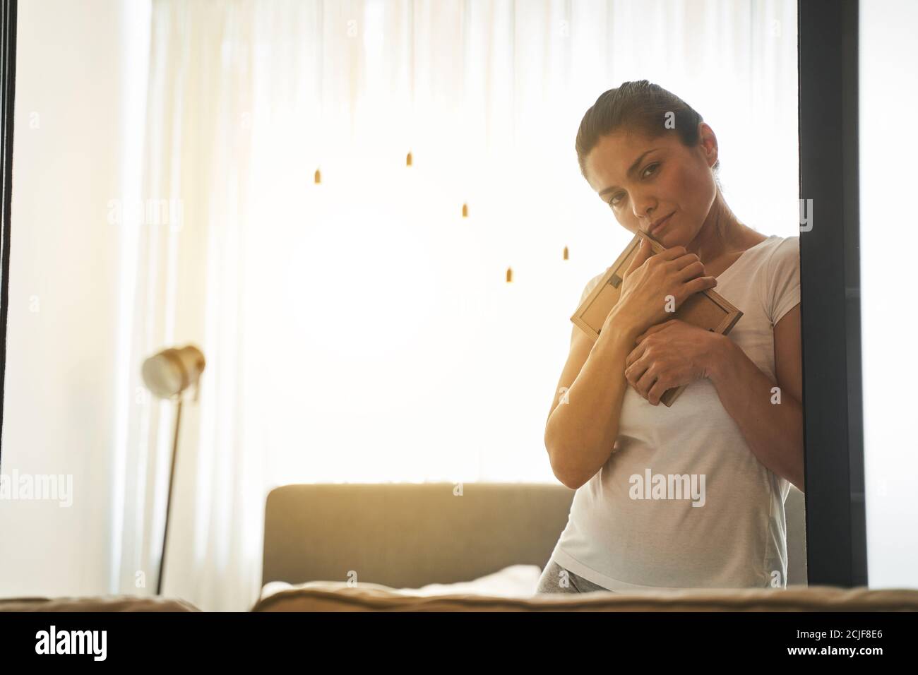 Woman hugging a photo in a frame Stock Photo - Alamy