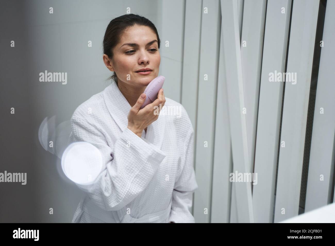 Focused lady performing a beauty procedure at home Stock Photo - Alamy