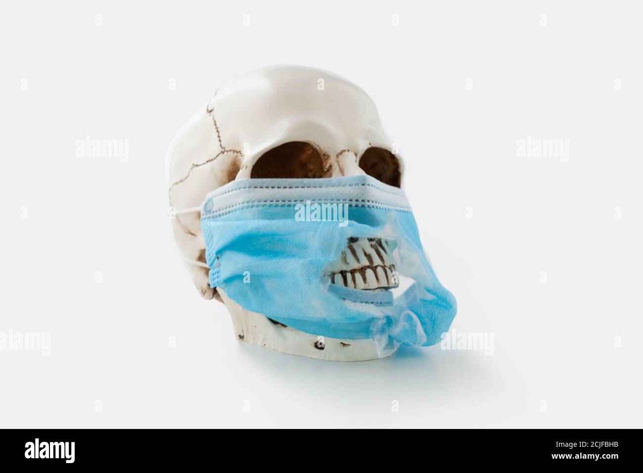 Human skull wearing blue surgical mask ripped and torn around the mouth ...
