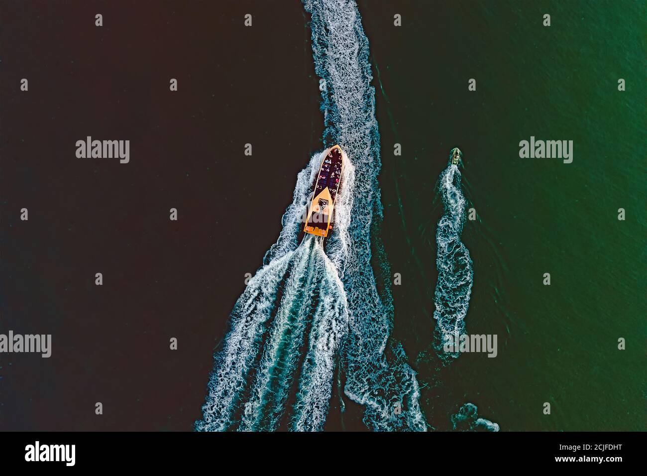 Aerial photo of yellow touristic speed boat sailing through the sea ...
