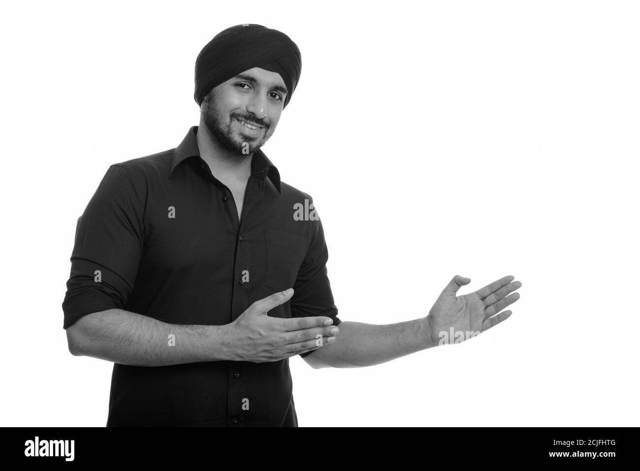 Young happy Indian Sikh man showing something Stock Photo - Alamy