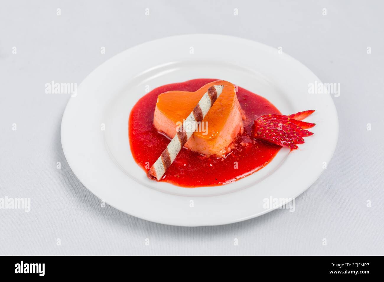 Heart-shaped pudding with strawberry sauce and wafer. Valentine's ...