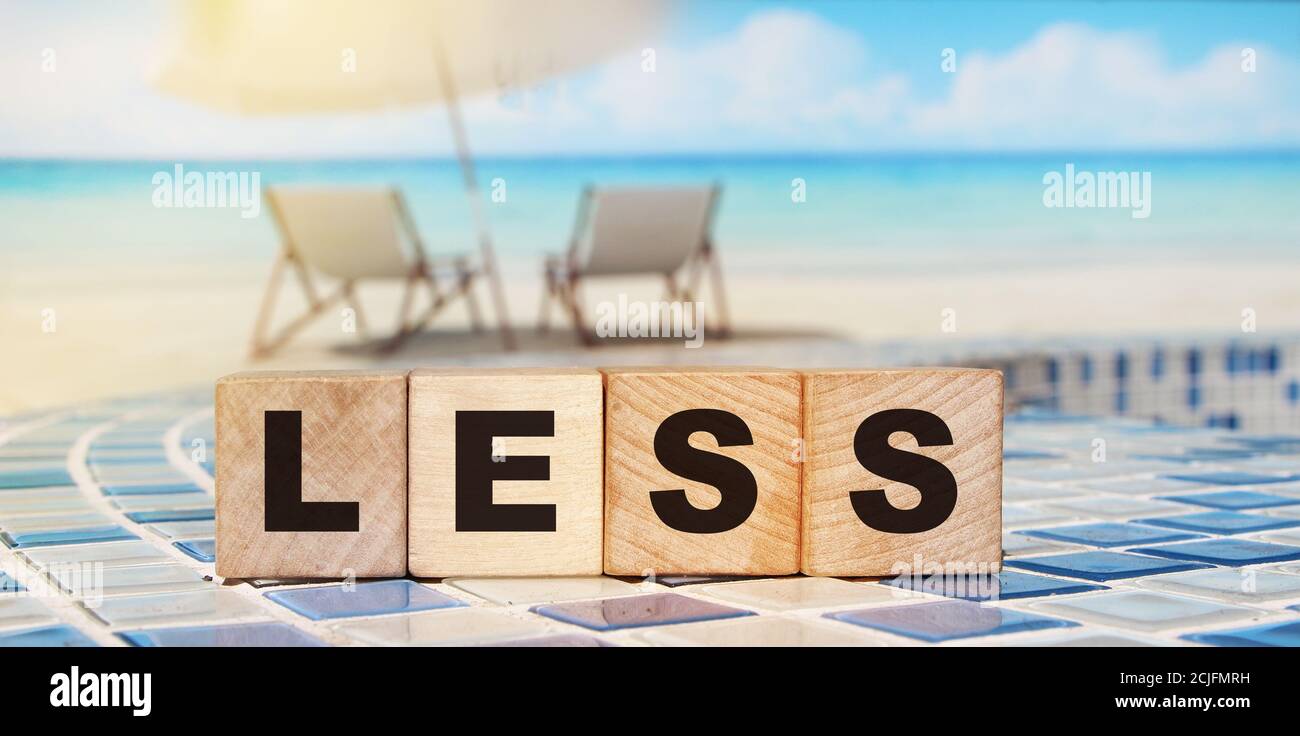 Less word on wooden blocks on ocean background. Less spend business ...