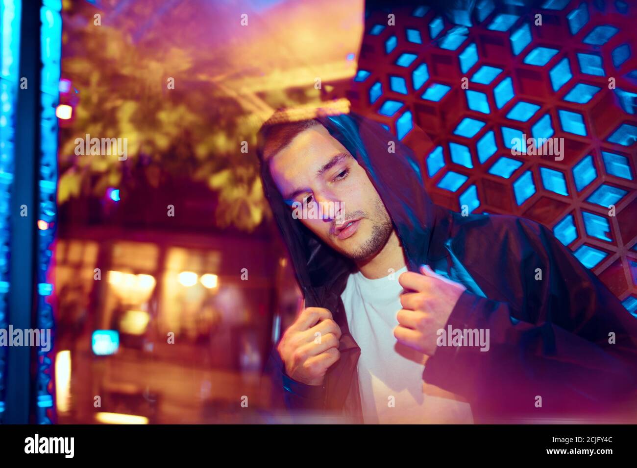 Moody guy. Cinematic portrait of stylish young man in neon lighted room ...