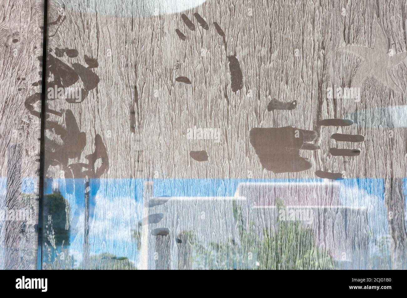 Image of the imprint of some hands on the white paint of a glass ...