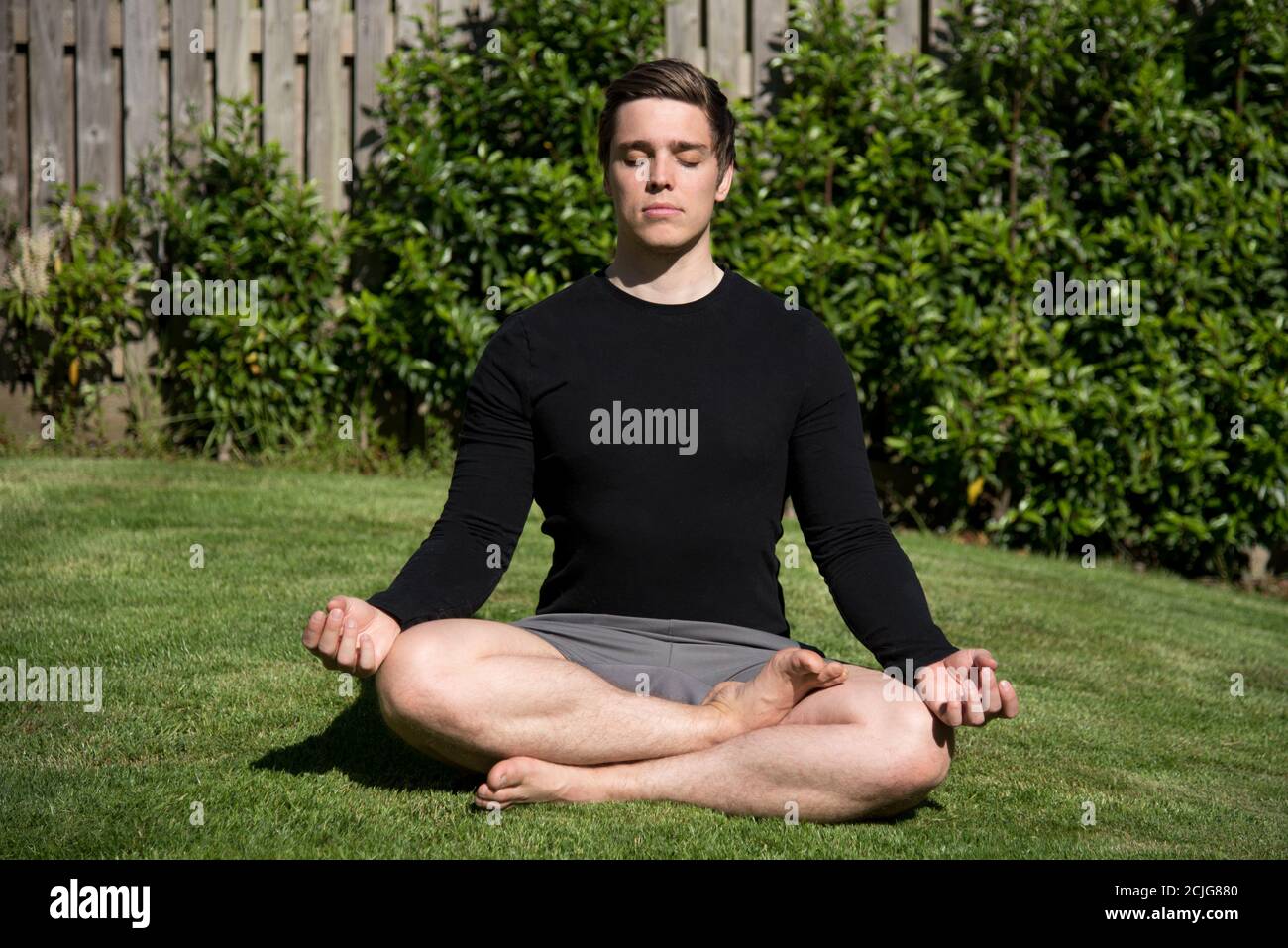 Young fit male doing the lotus yoga position outdoors Stock Photo - Alamy