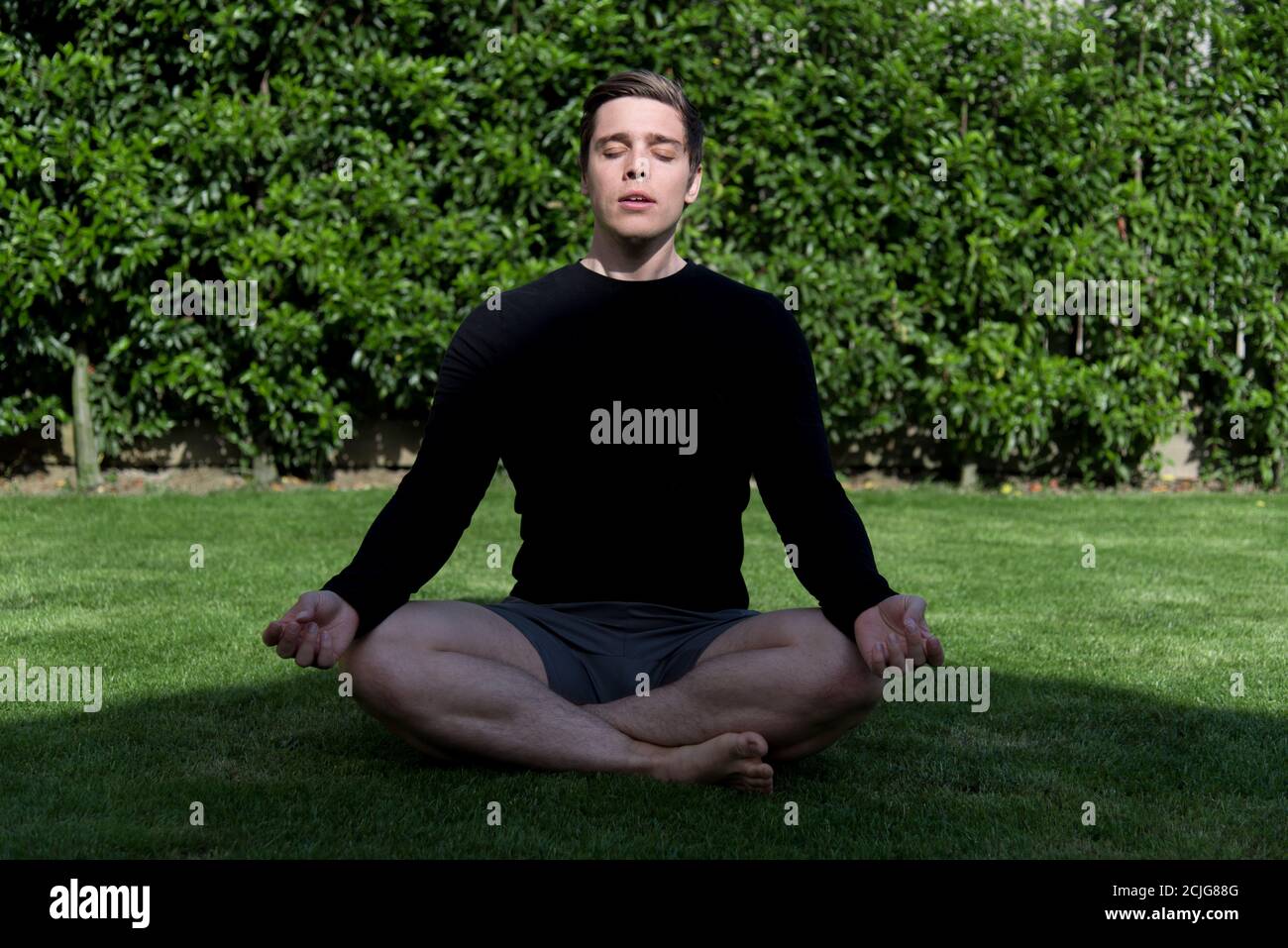 Young fit male doing the lotus yoga position outdoors Stock Photo - Alamy