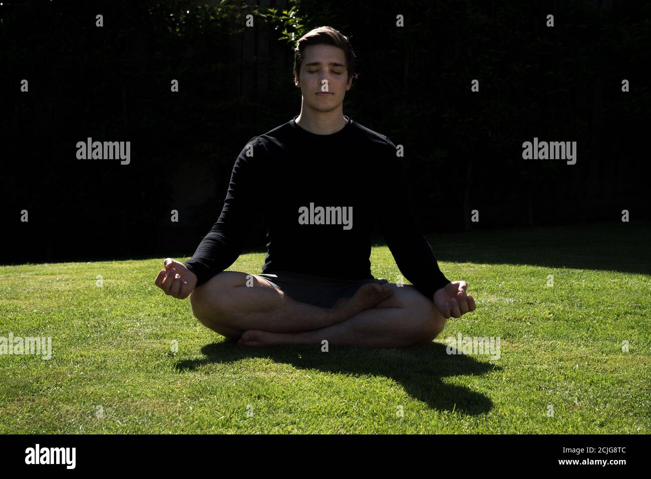Young fit male doing the lotus yoga position outdoors Stock Photo - Alamy