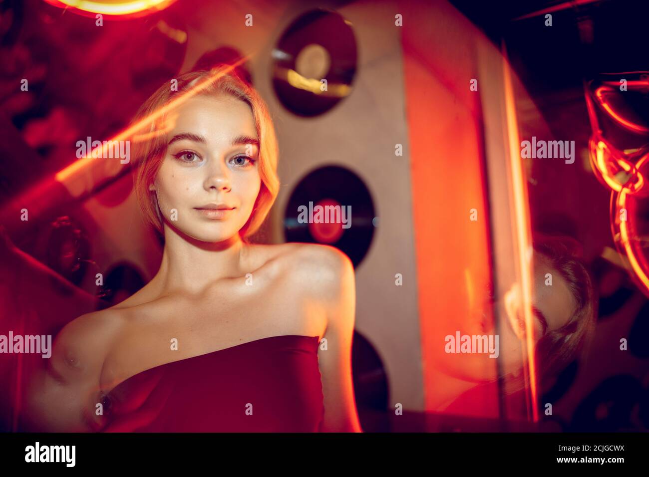 Celebrities. Cinematic portrait of stylish young woman in neon lighted ...