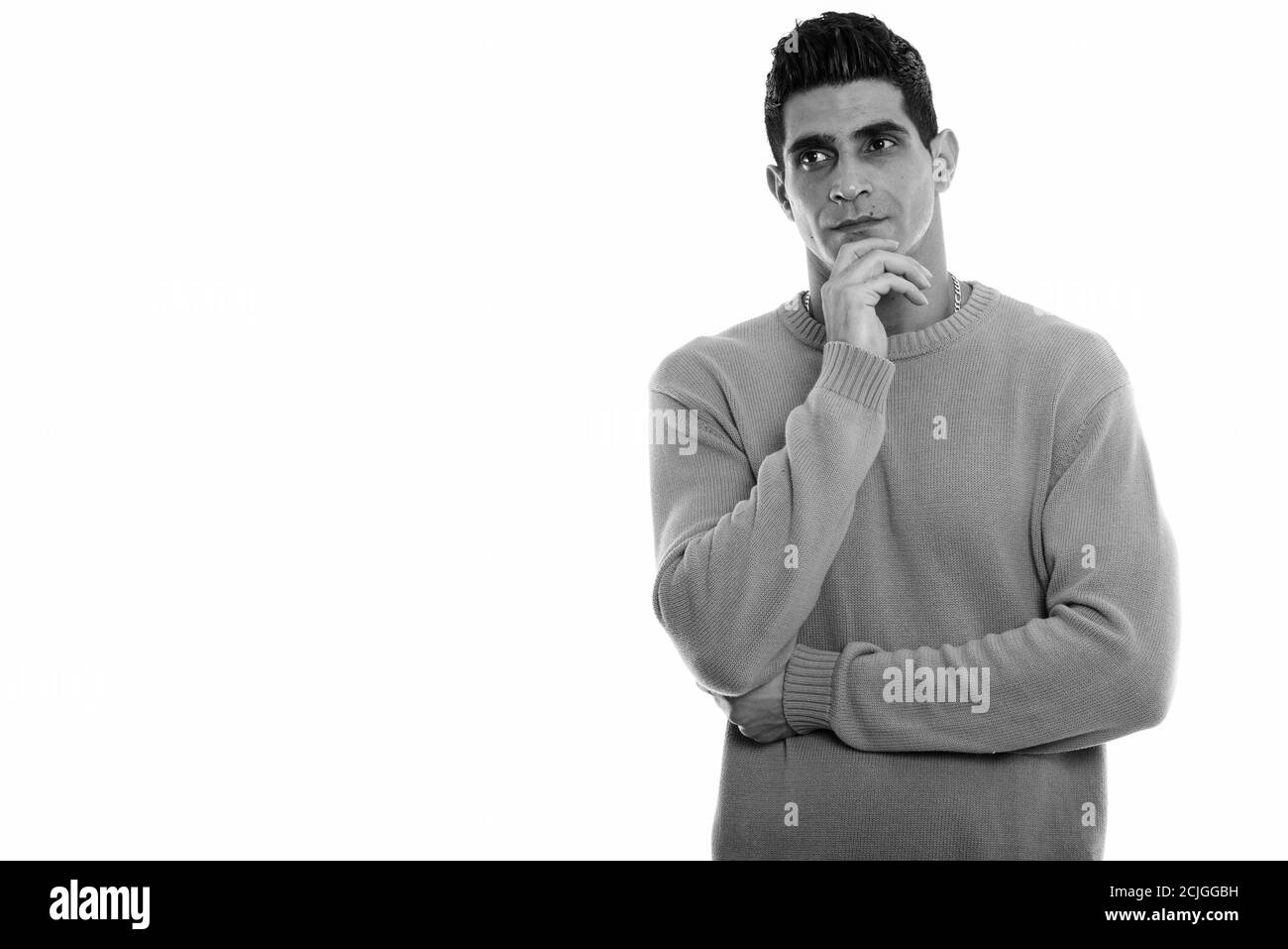 Studio shot of young muscular Persian man thinking while looking away ...