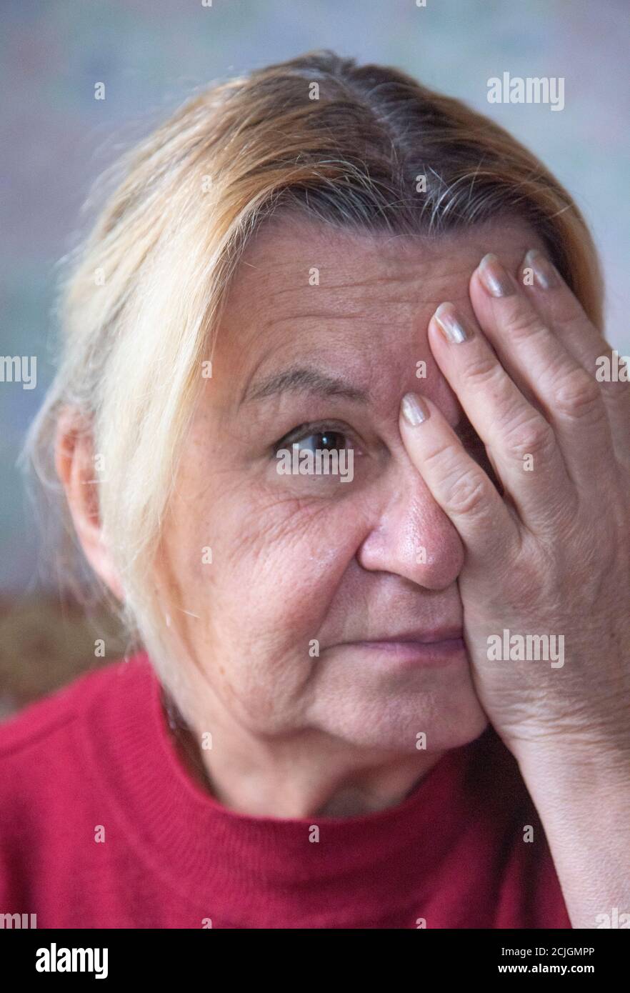 Portrait of an elderly woman holding her head with her hand Stock Photo ...