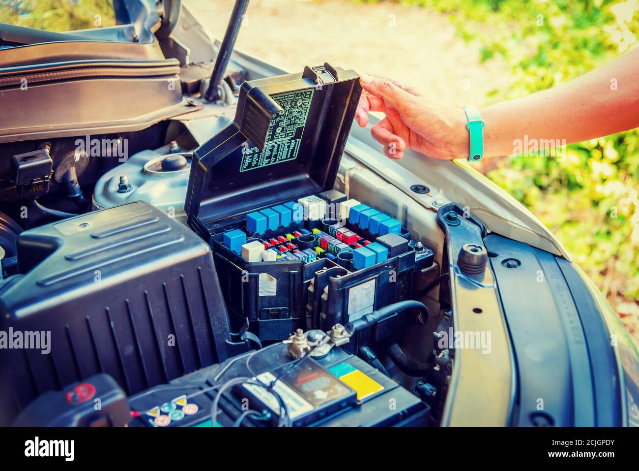 Close up of a man opening the fuse box of a modern car Stock Photo - Alamy