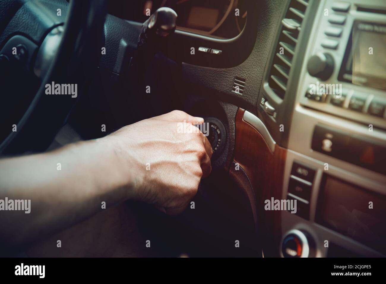 Close up of a man starting a luxury car. Man's hand holding a car key ...