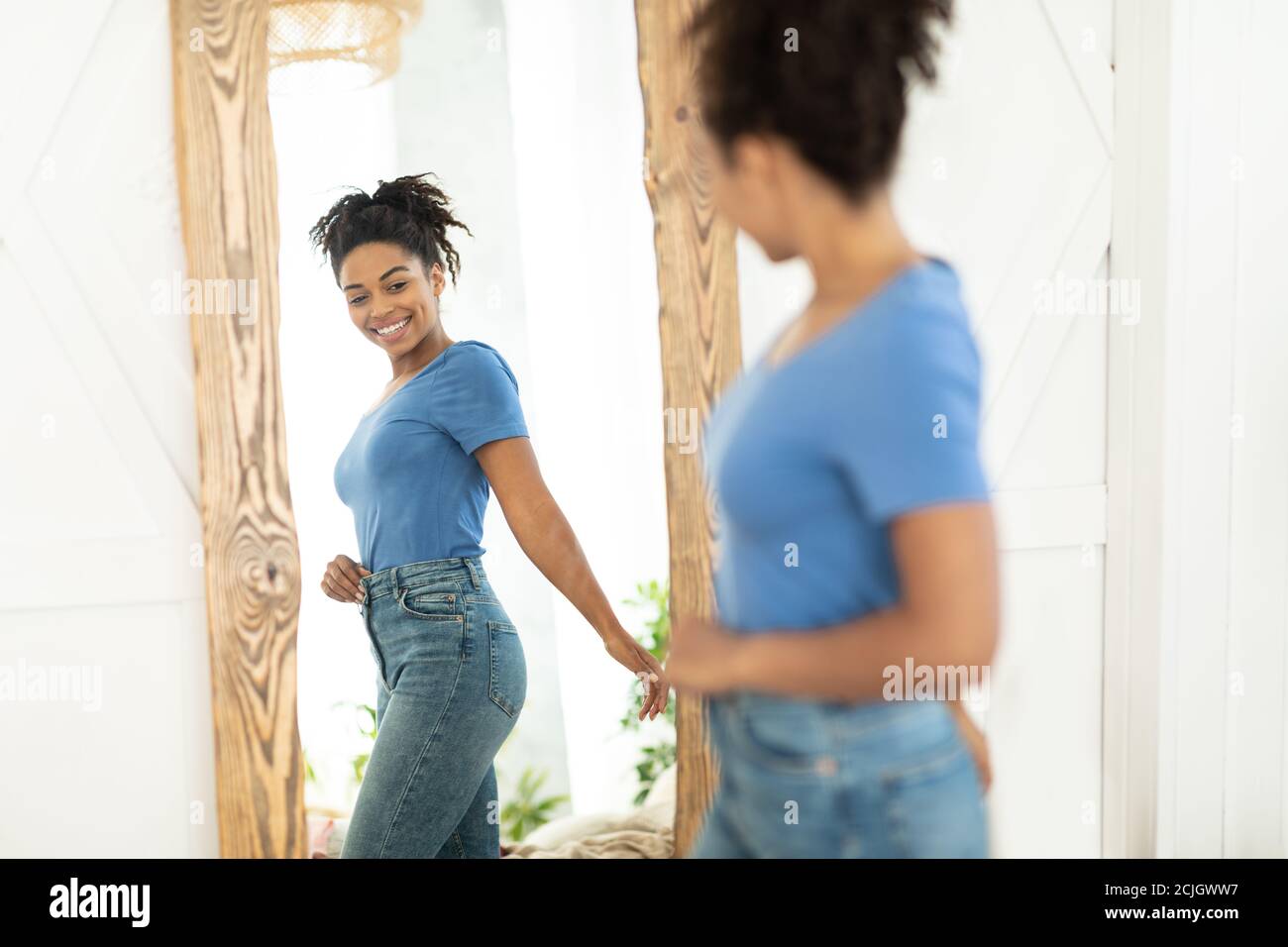 Cheerful Slim Black Girl Looking At Reflection In Mirror Indoor Stock ...