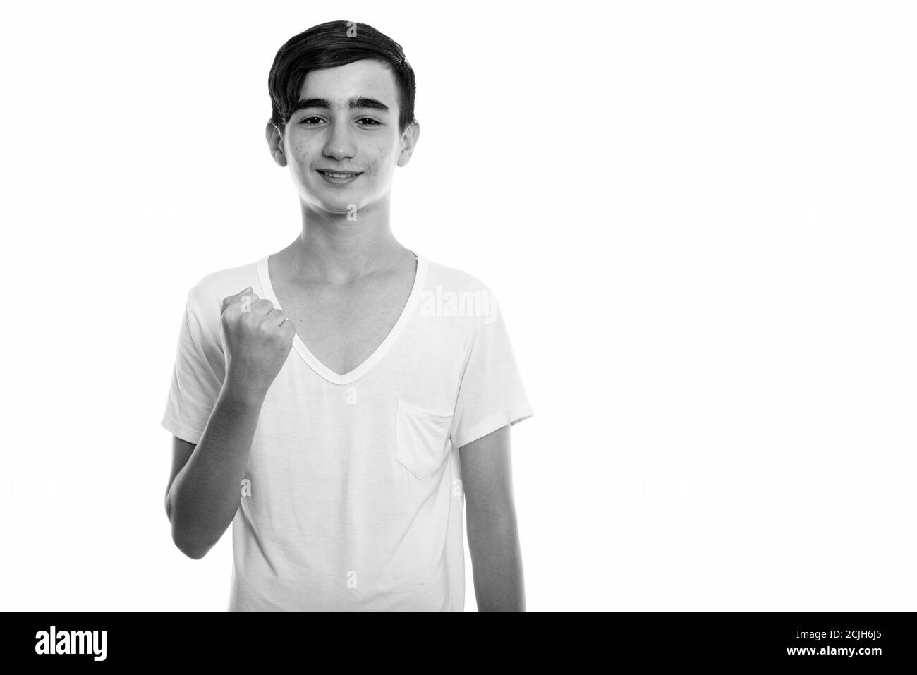 Studio shot of young happy Persian teenage boy smiling while looking ...