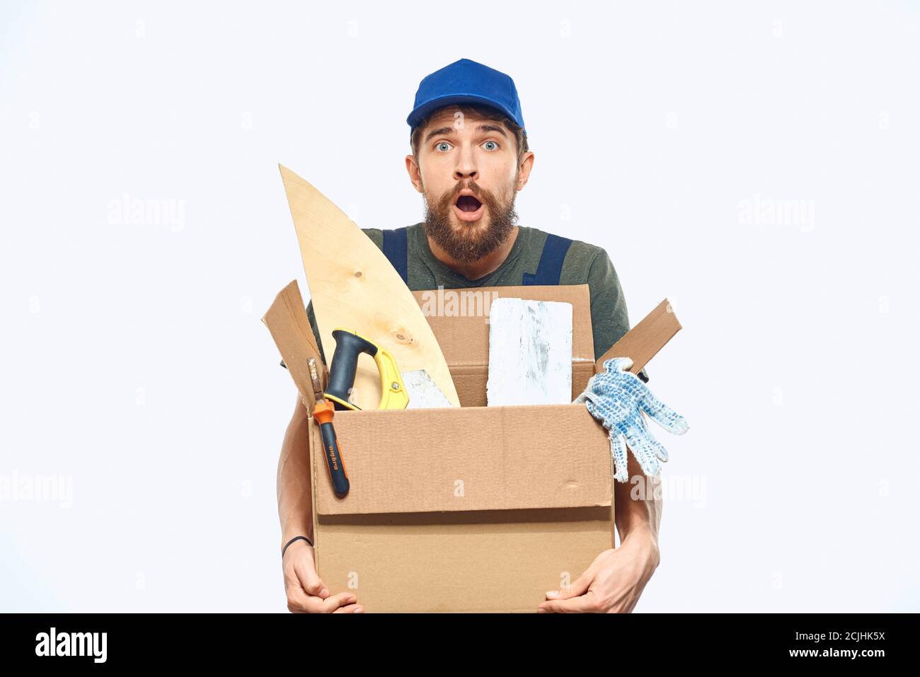 Worker man in uniform with a box in his hands tools delivery service ...