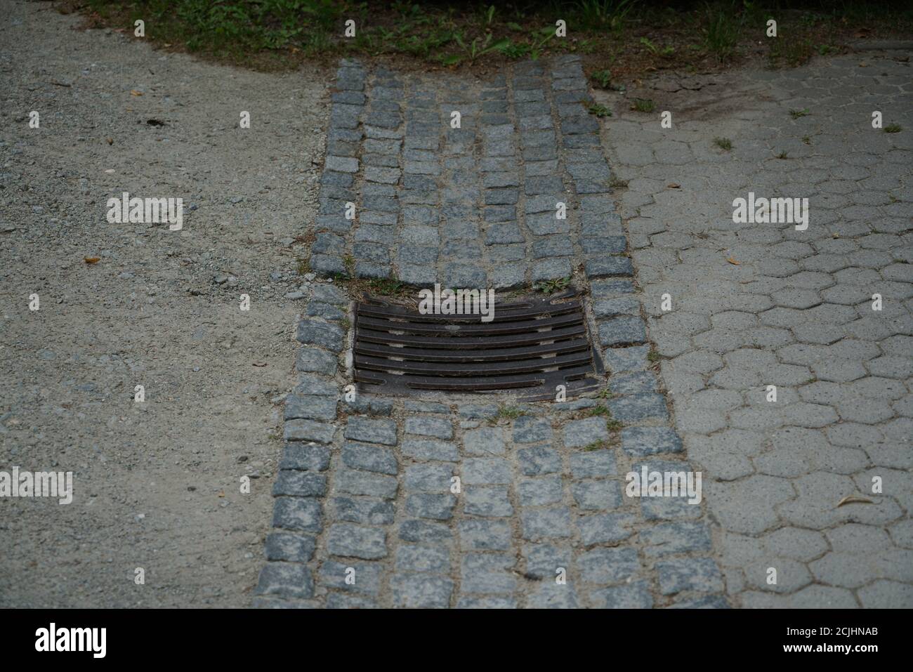 Metal drainage on cobblestone path Stock Photo - Alamy