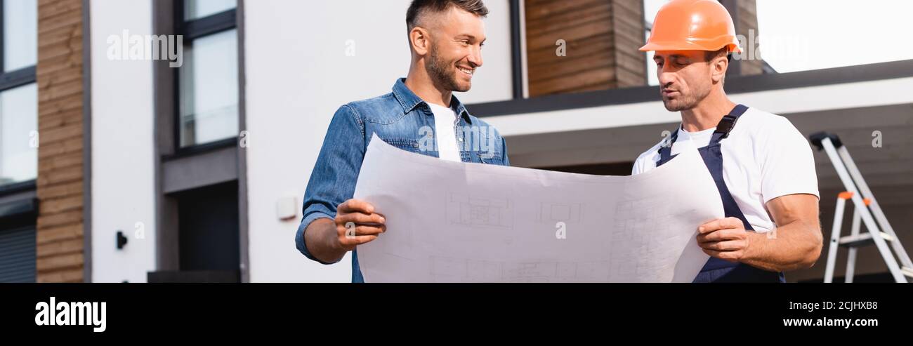 Horizontal concept of man holding blueprint near builder in uniform ...