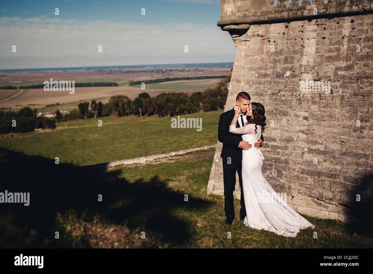 Newlywed couple posing near old castle wall, fairytale wedding at ...