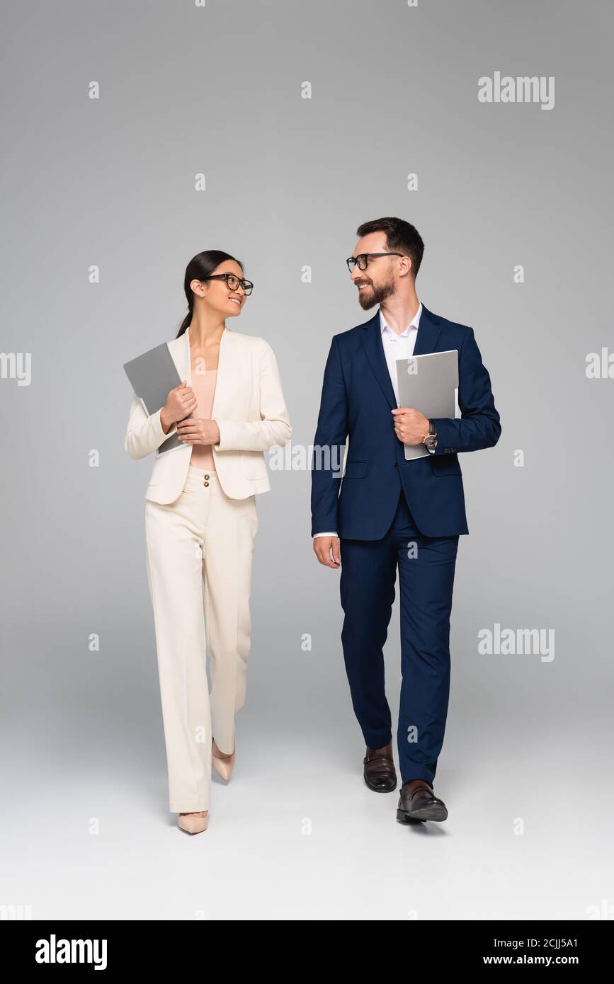 interracial couple of business partners holding folders and looking at ...