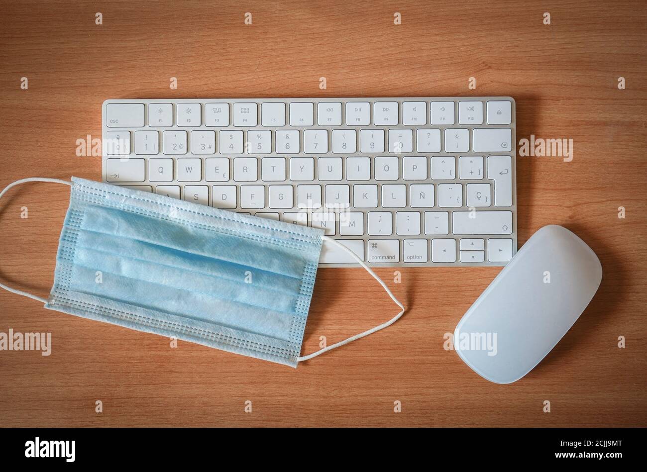 Surgical mask next to a keyboard and computer mouse. Concept of Covid ...