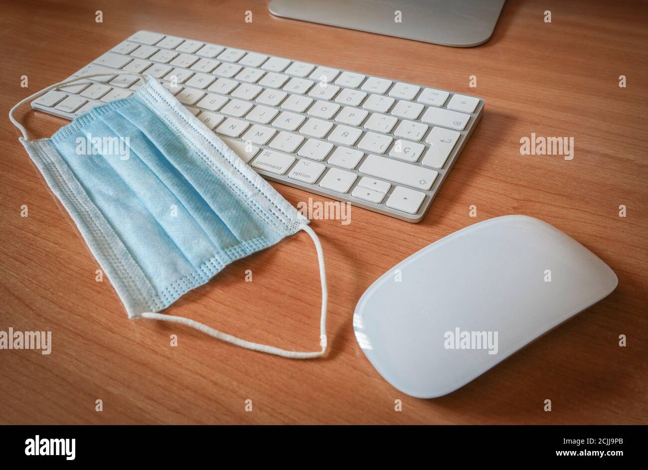 Surgical mask next to a keyboard and computer mouse. Concept of Covid ...