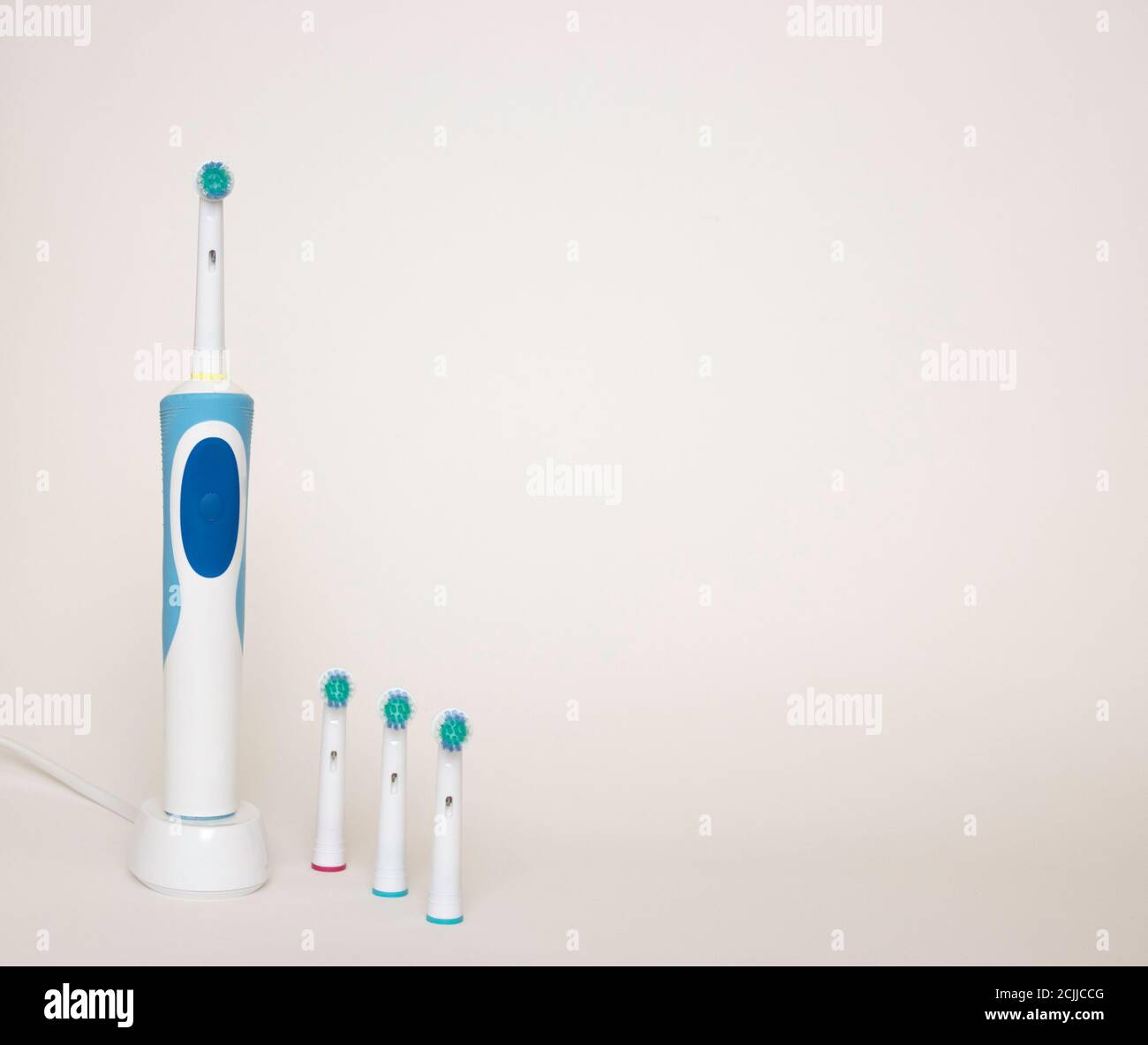 Electric toothbrush on the stand charger and removable parts from it on ...