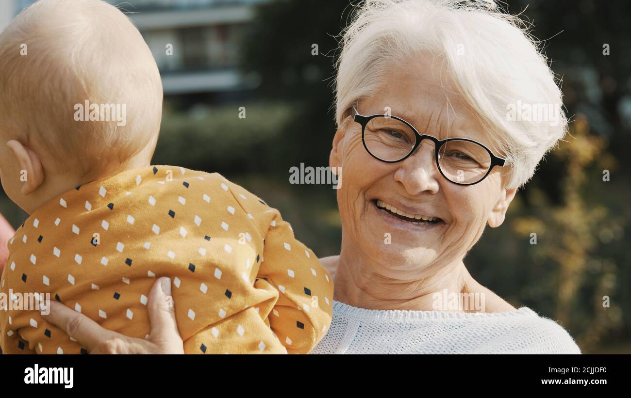Happy grandmother holding her grandson baby boy in the nature. High ...