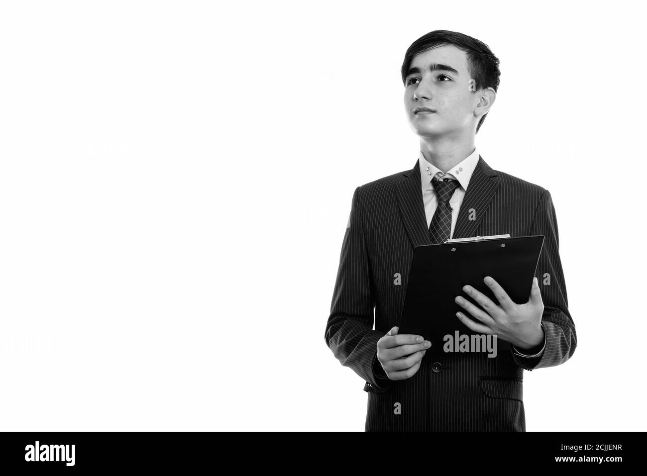 Studio shot of young handsome Persian teenage businessman holding ... Studio shot of young handsome Persian teenage businessman holding ...