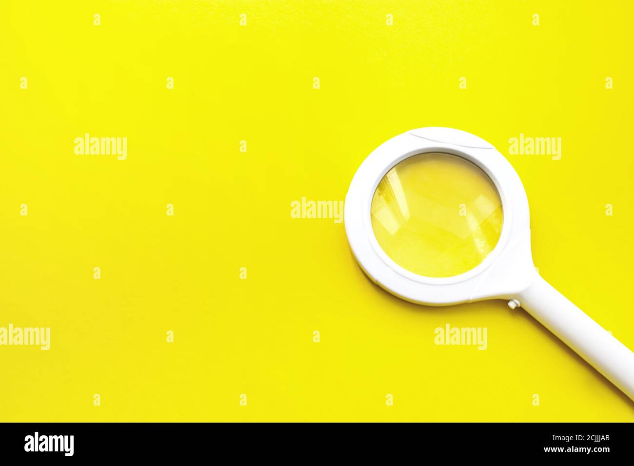 High Angle View Of Magnifying Glass Over Yellow Background. Magnifying ...