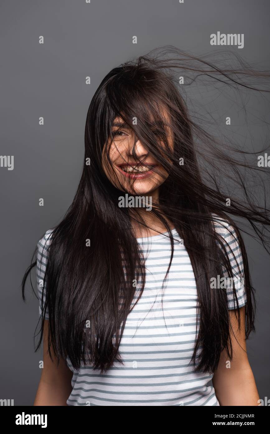 wind blowing through hair of brunette woman isolated on black Stock ...