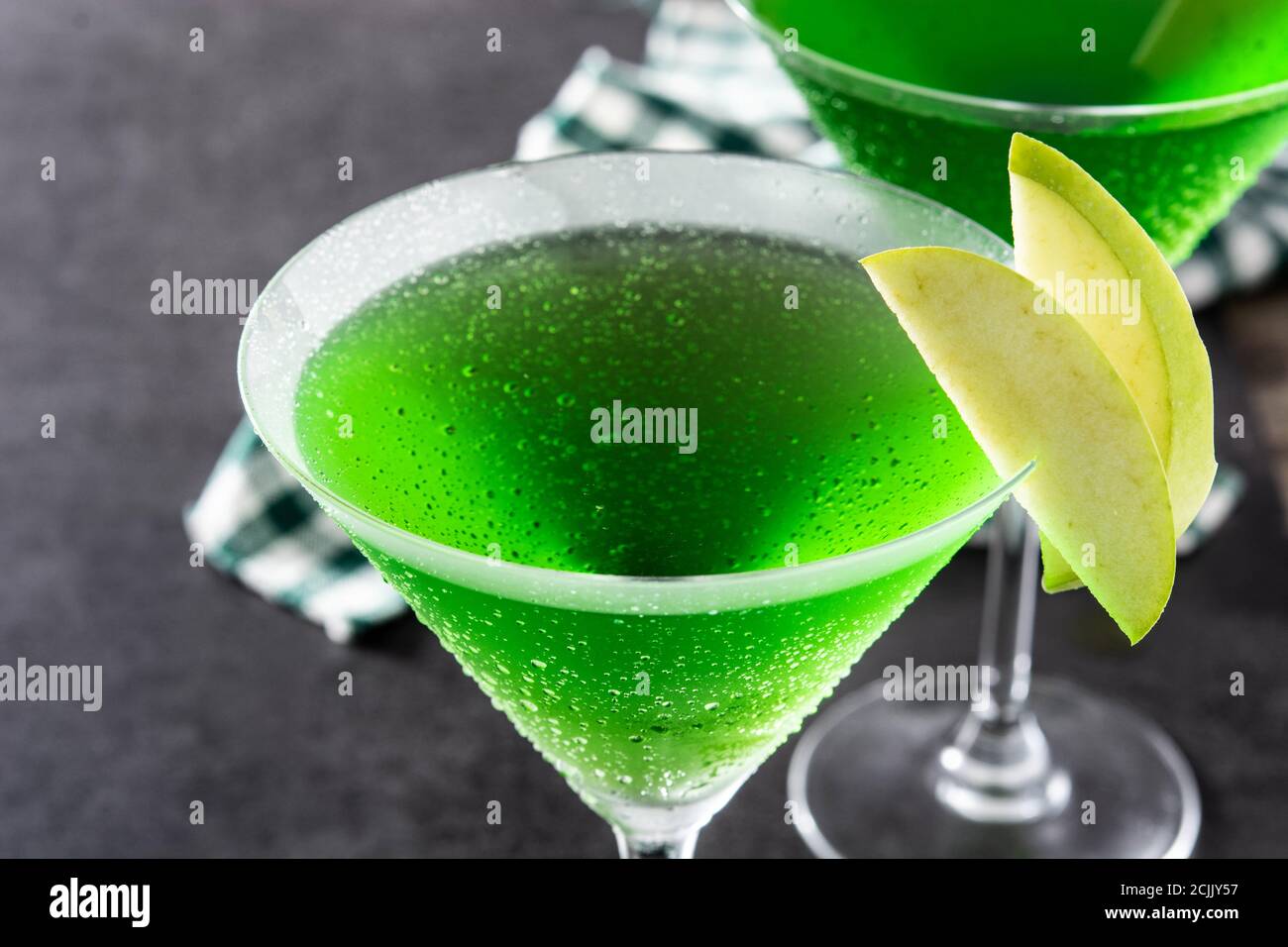 Green appletini cocktail in glass on black background Stock Photo - Alamy