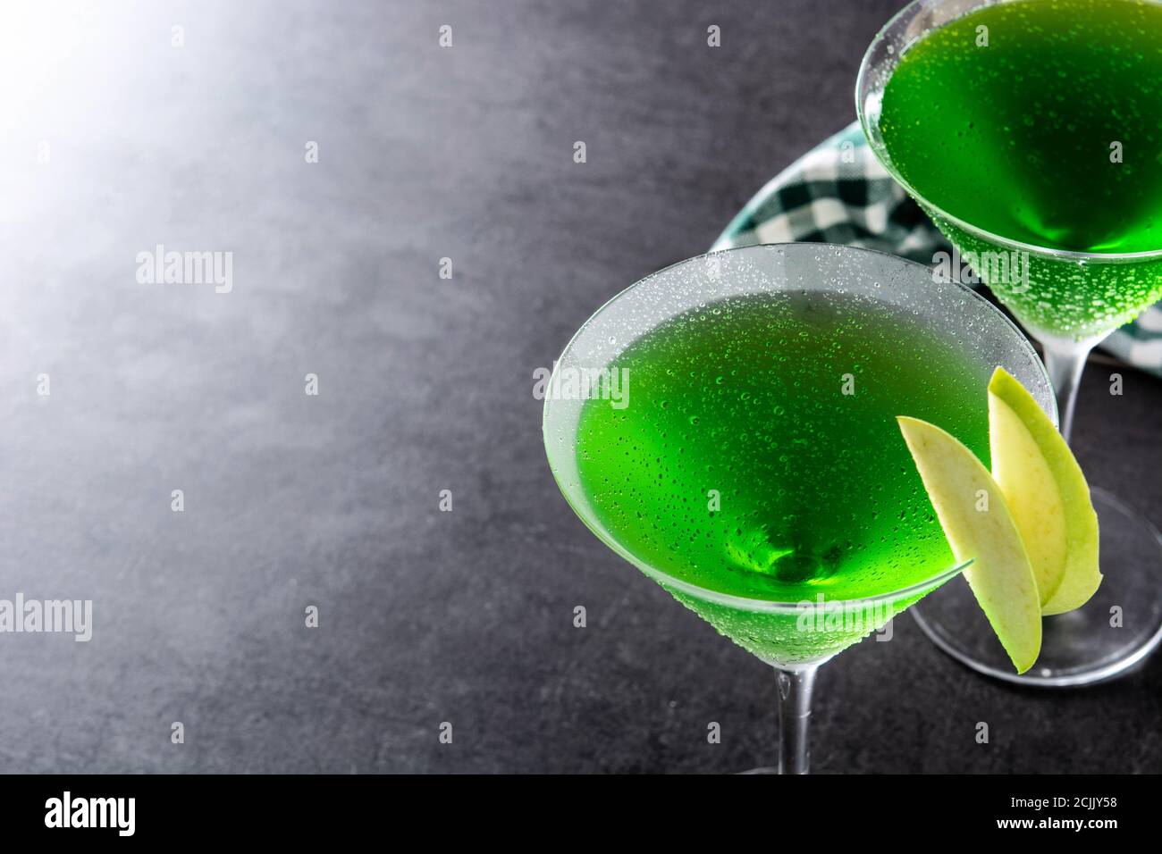 Green appletini cocktail in glass on black background Stock Photo - Alamy