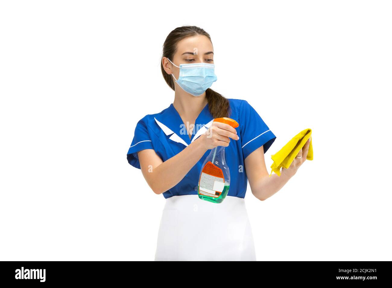 Using cleaner and face mask. Portrait of female made, housemaid ...