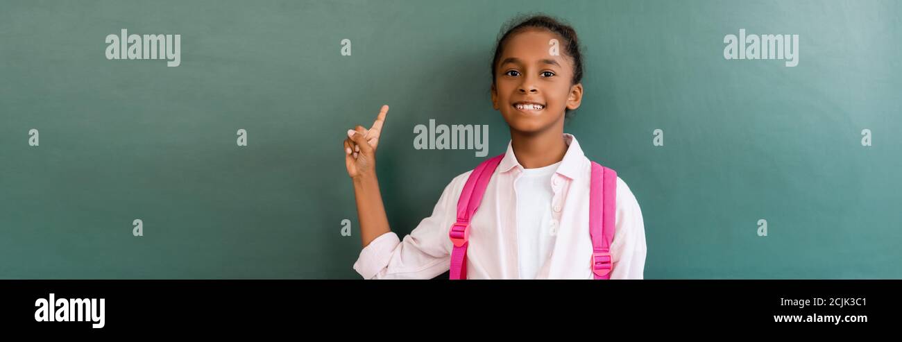 Horizontal concept of african american schoolgirl pointing at green ...