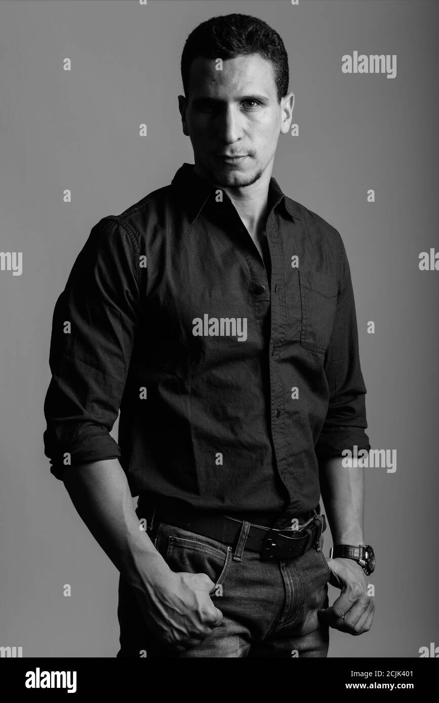 Studio shot of young muscular Persian man standing with hands on ...