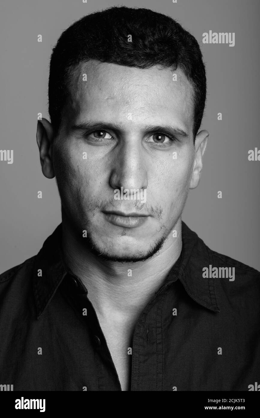 Face of young muscular Persian man against gray background Stock Photo ...