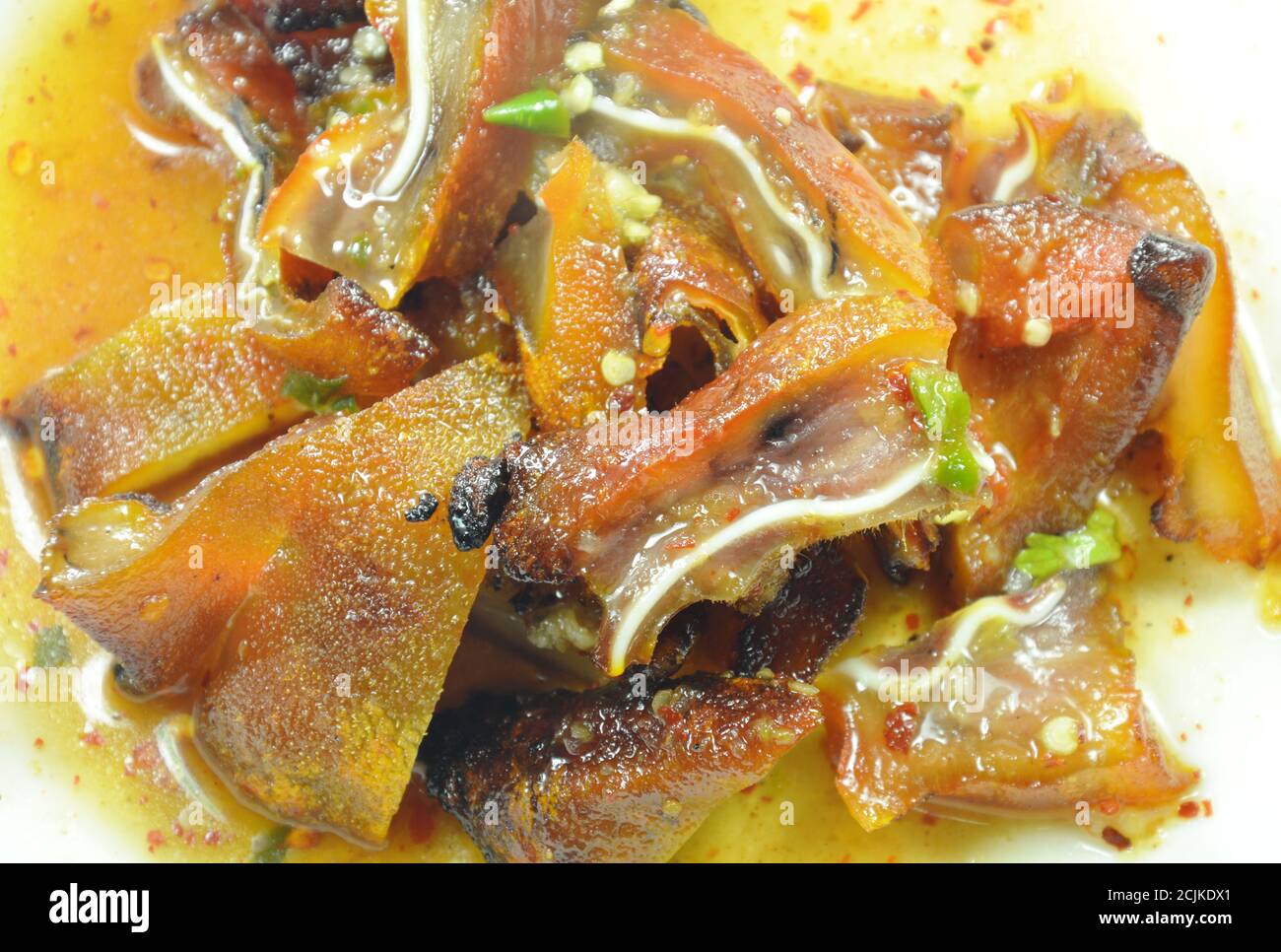 grilled pork ear slice dressing spicy sauce on plate Stock Photo - Alamy