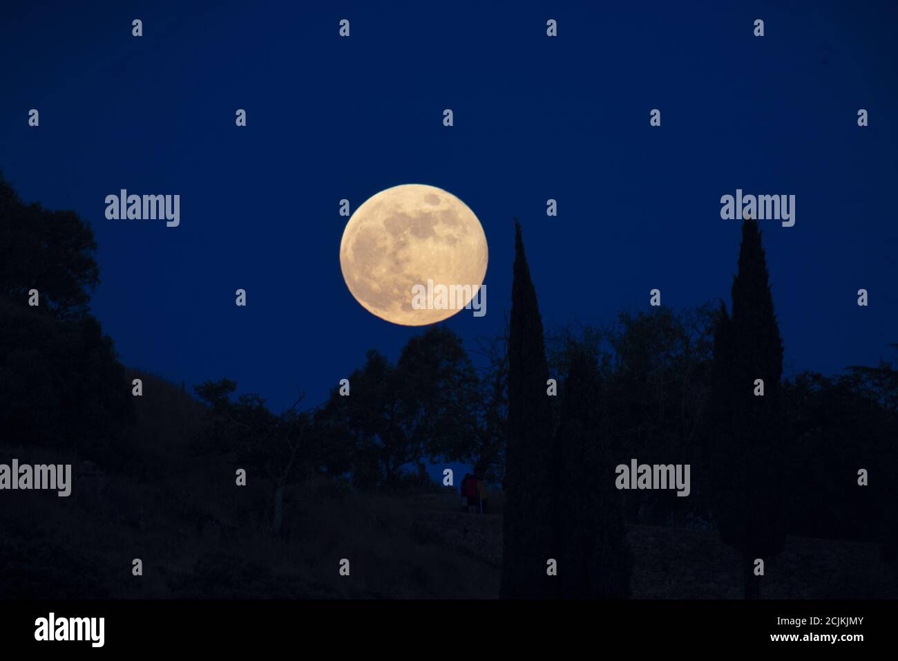 Beautiful scenery of the full moon over a landscape with tall buildings ...