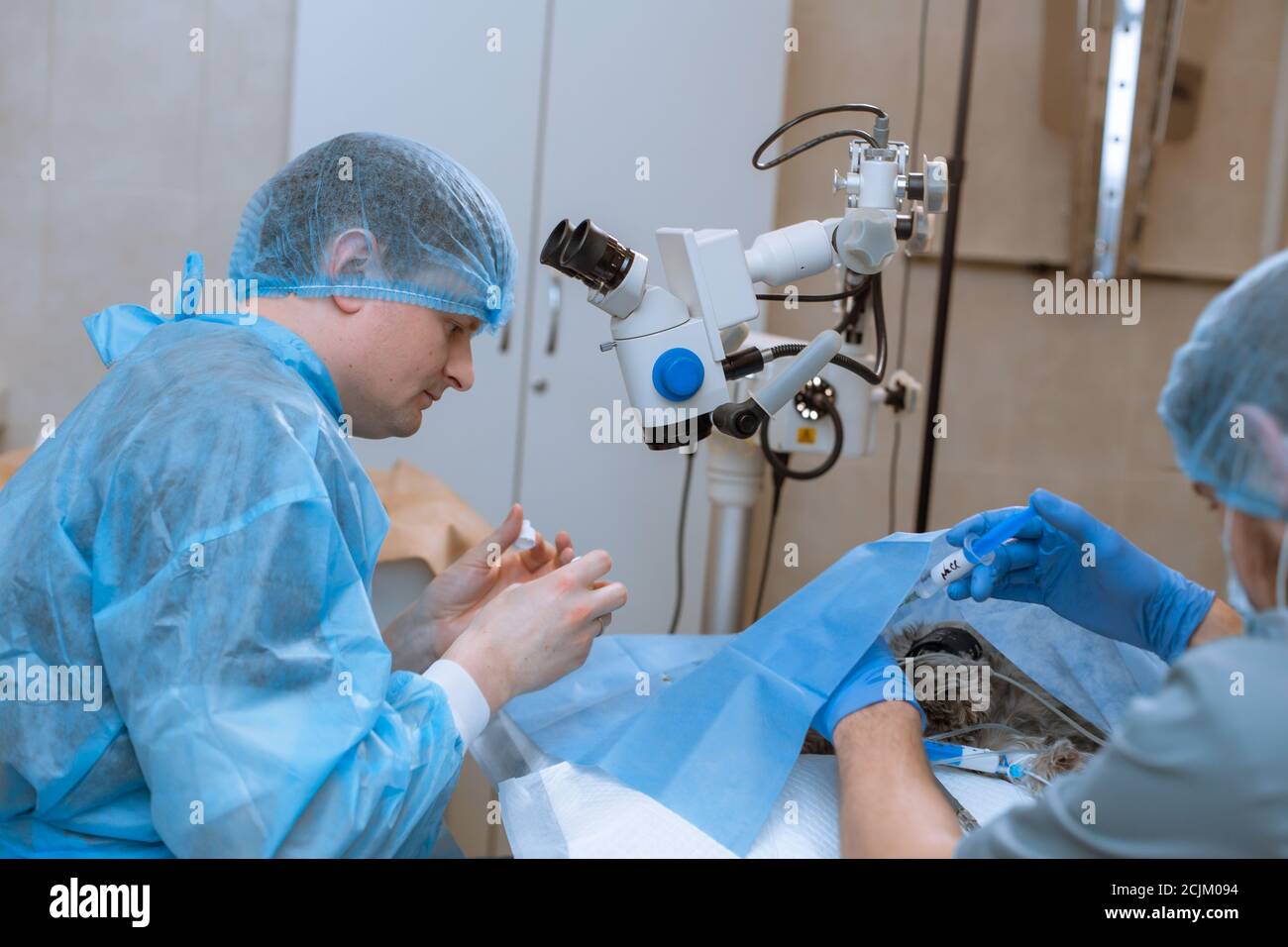A professional ophthalmologist performs eye surgery with a microscope ...