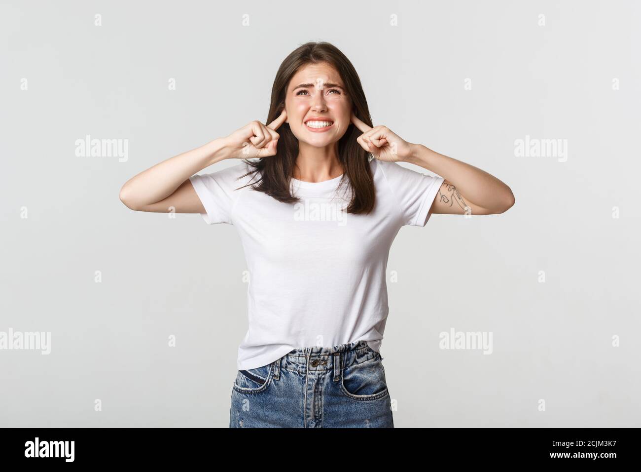 Annoyed and bothered girl shut ears and complaining at loud awful noise ...