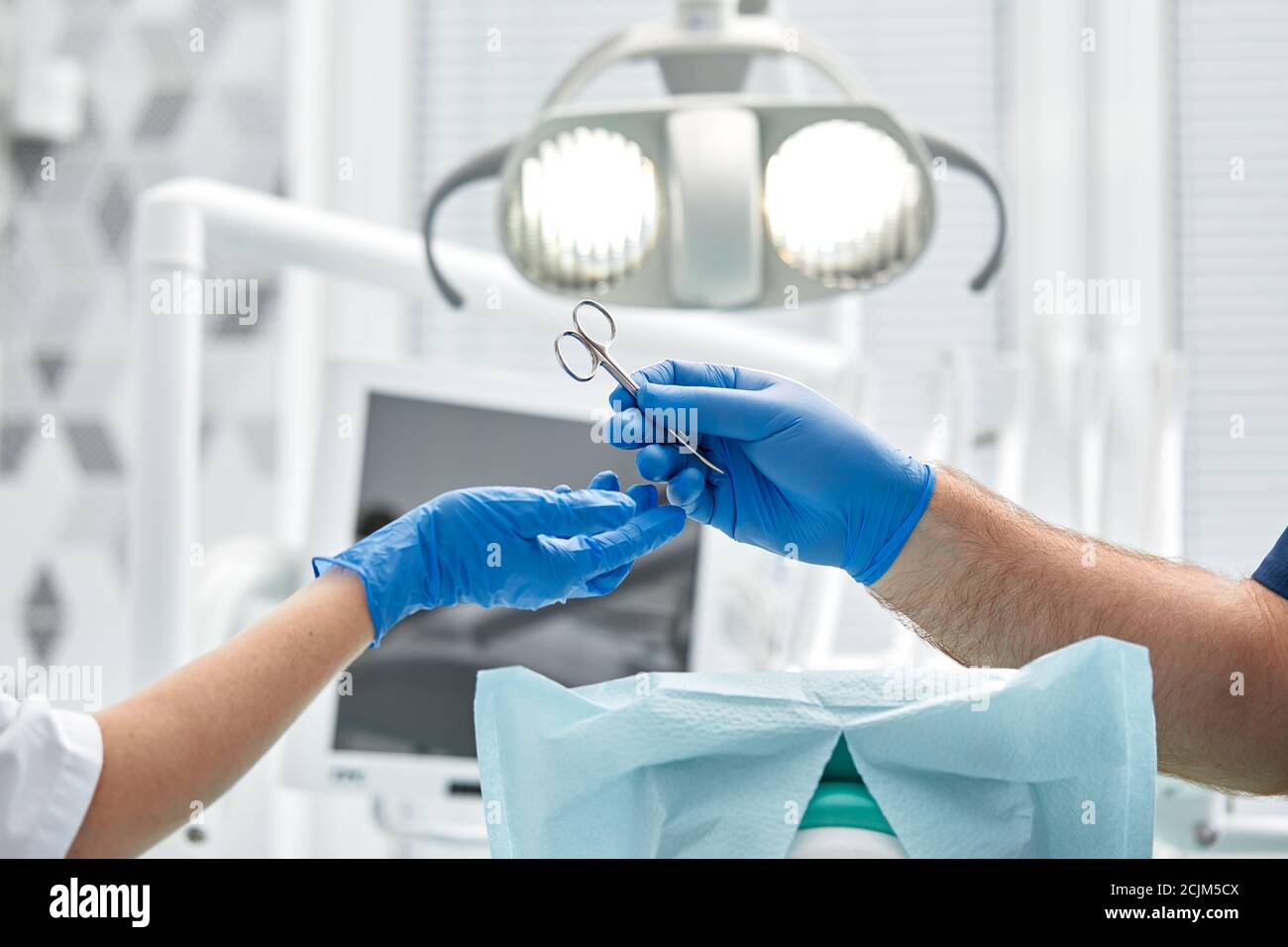 Close-up of the hands of a dentist and nurse surgeon over an operating ...