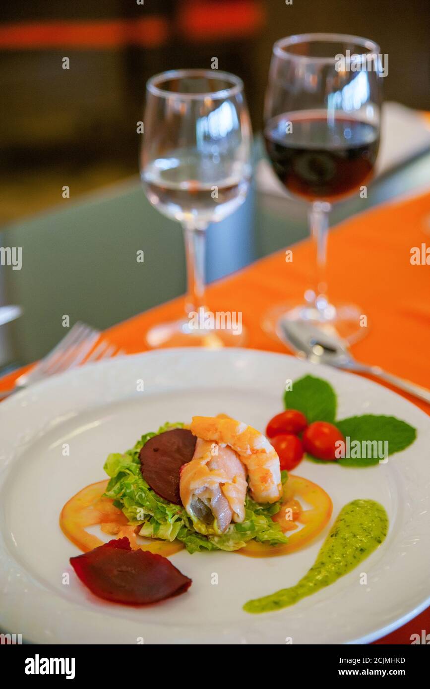 Elegant seafood starter plate with stuffed fish and prongs on a bed of ...