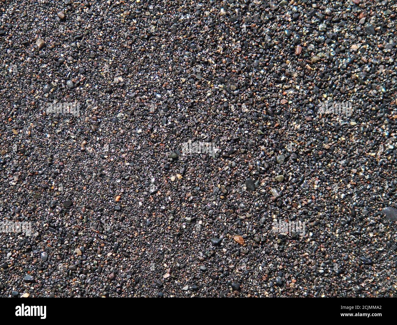 Abstract volcanic grained sand with small pebbles and basaltic surface ...