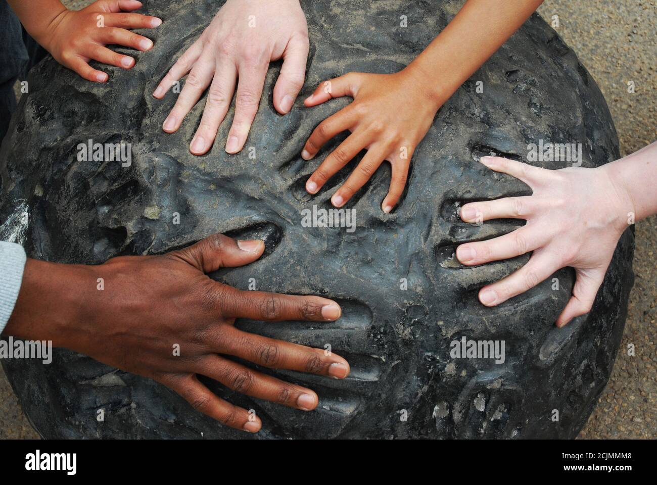 Multiple hands of different races fit into hand-prints on a piece of ...