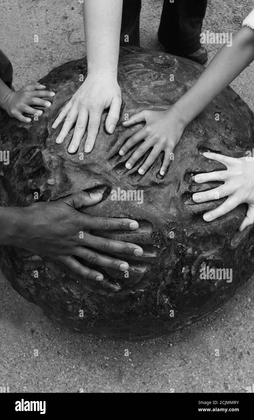 Multiple hands of different races fit into hand-prints on a piece of ...